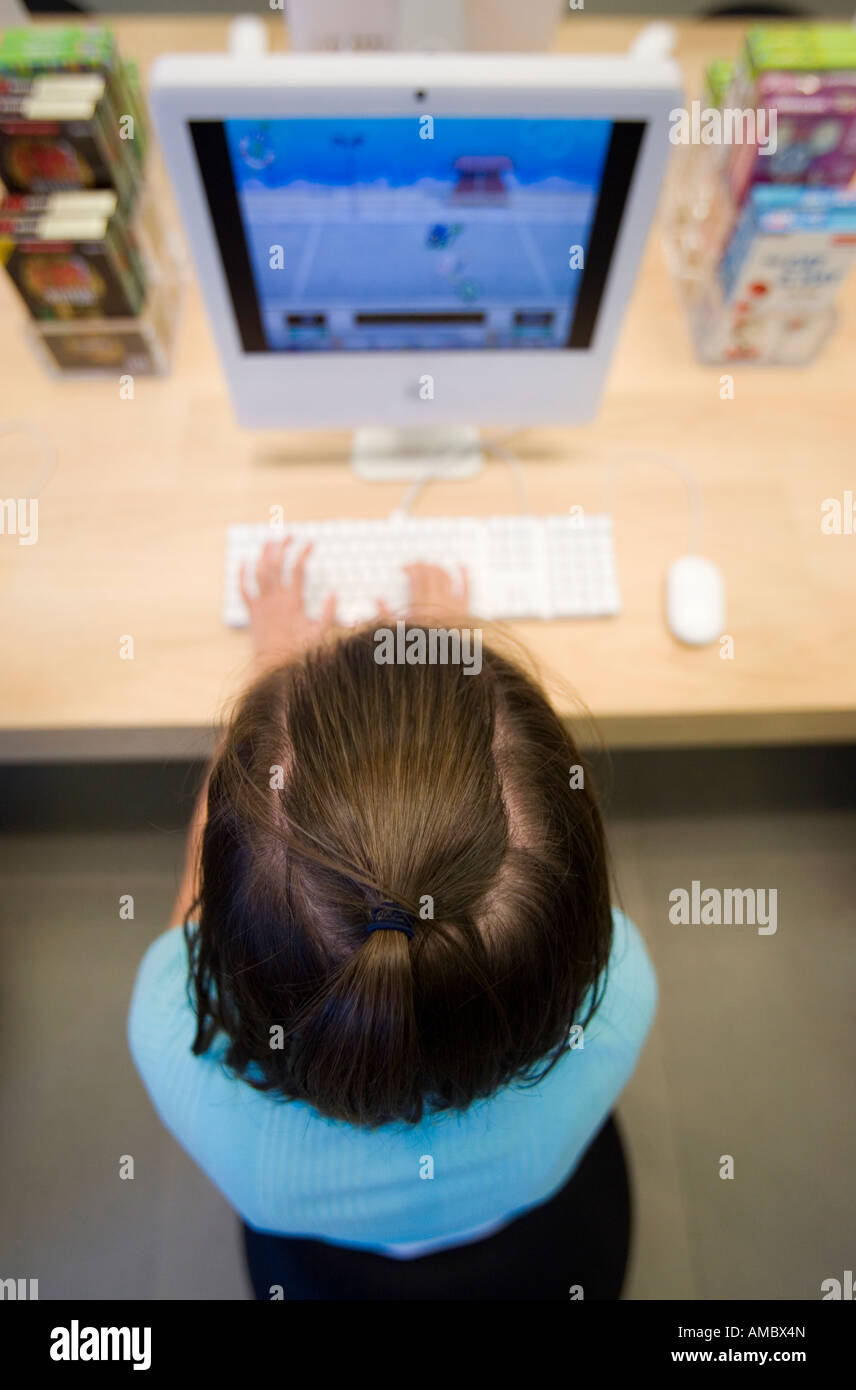 A young girl sitting and typing on a computer Stock Photo - Alamy