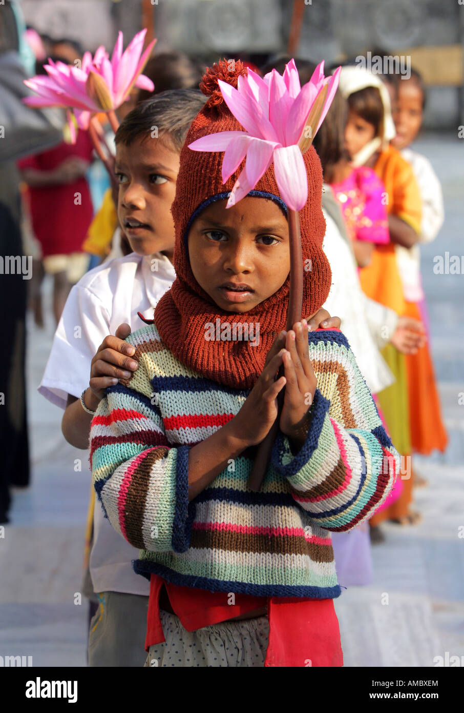 India, Bodhgaya: young buddhist children with lotus flowers visiting ...