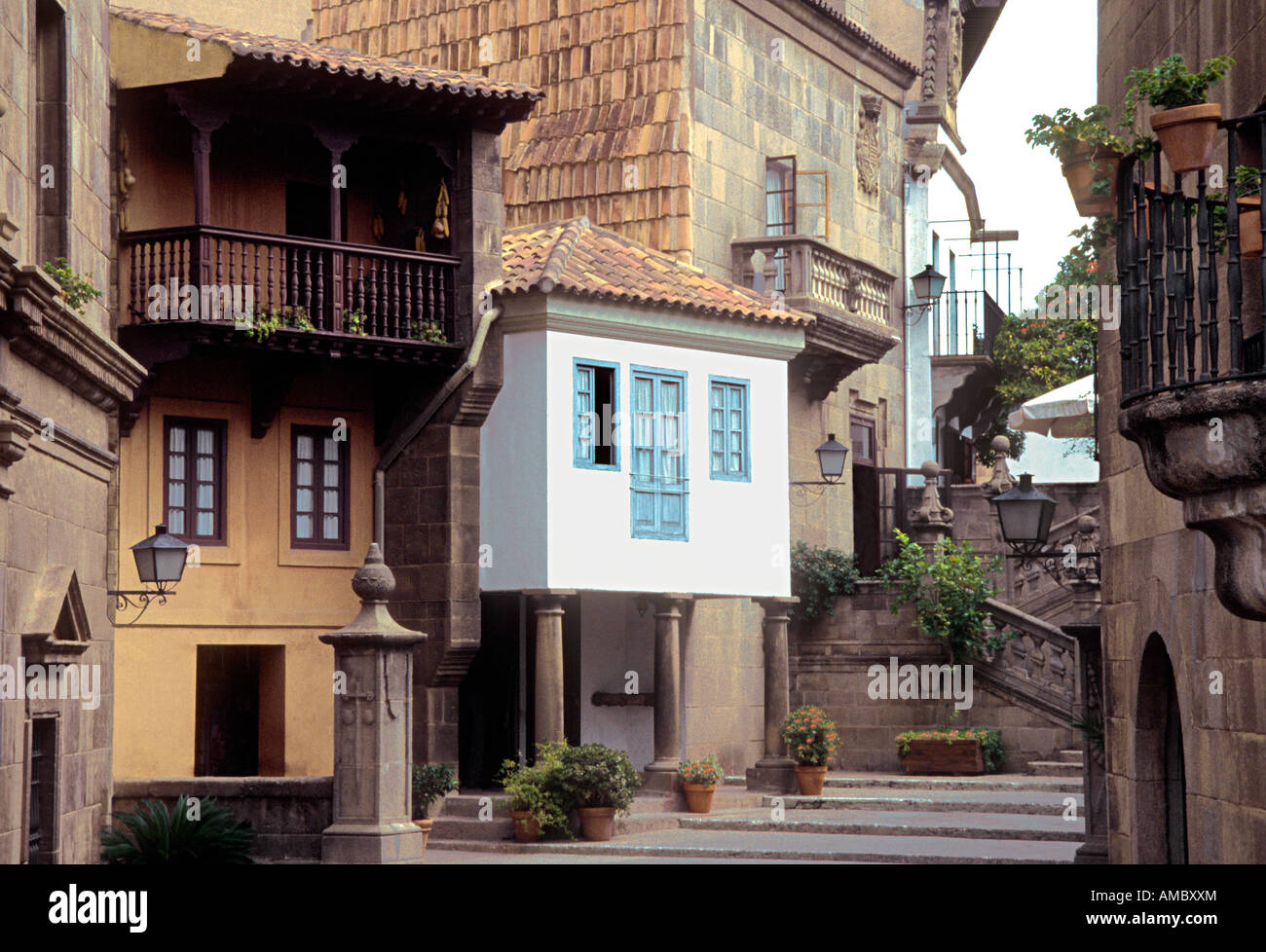 A white plaster house on pillars surrounded by stone built houses in a ...