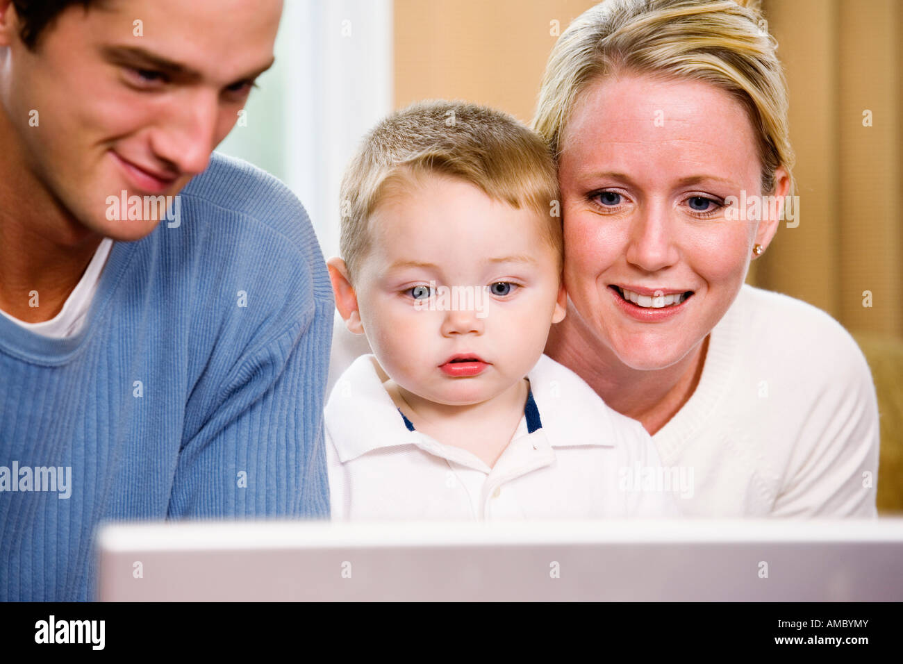 View of parents teaching their son to use a computer Stock Photo - Alamy