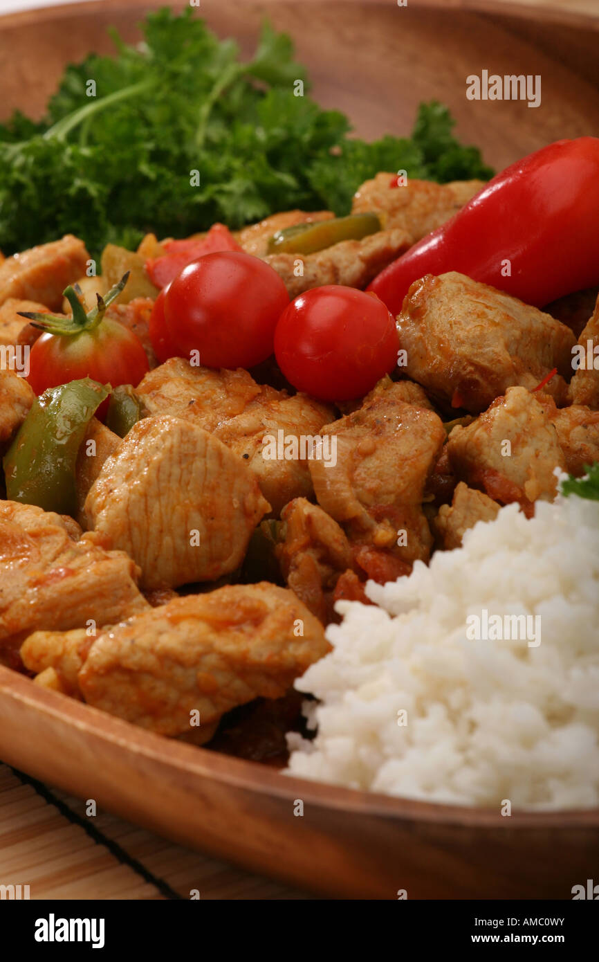 Pork stewed with a white rice and vegetable garnish on a plate from ...