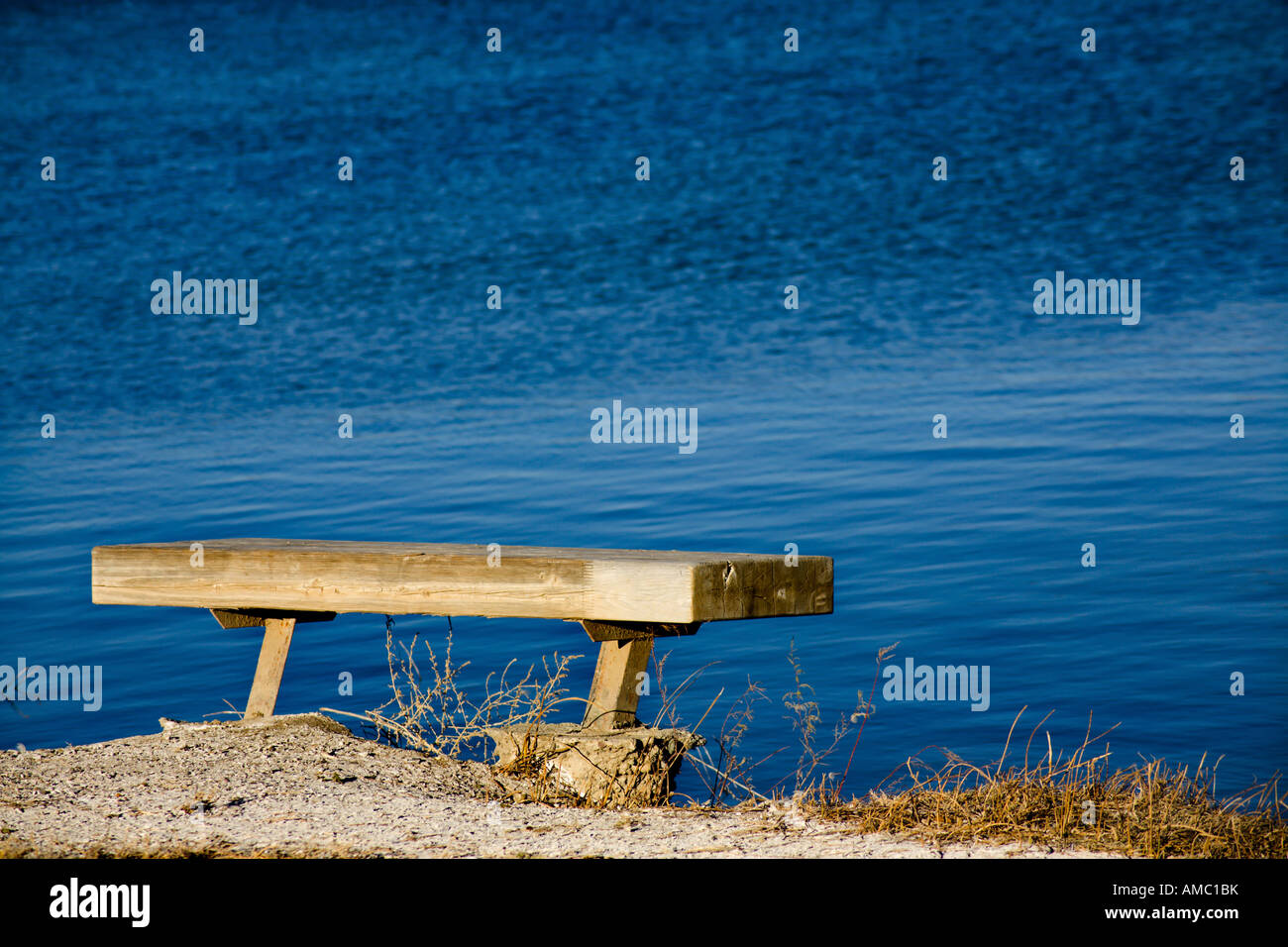 An open bench on the side of a lake Stock Photo - Alamy