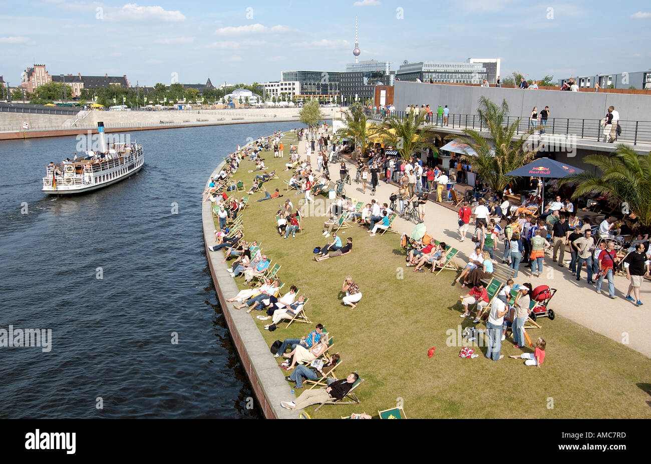 People sitting beside Spree River promenade on newly landscaped ...