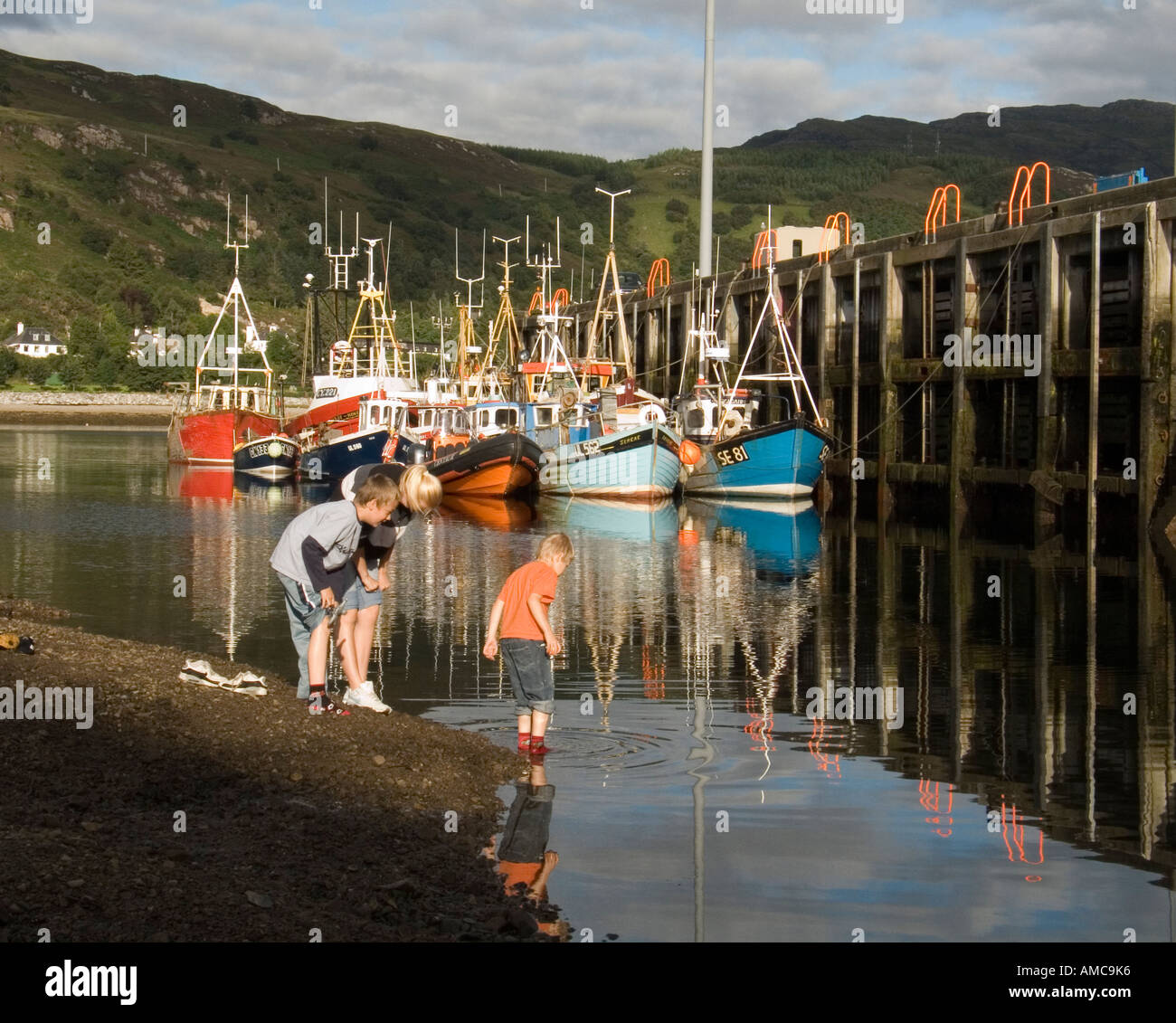 Ullapool Harbour Children looking into water Stock Photo - Alamy