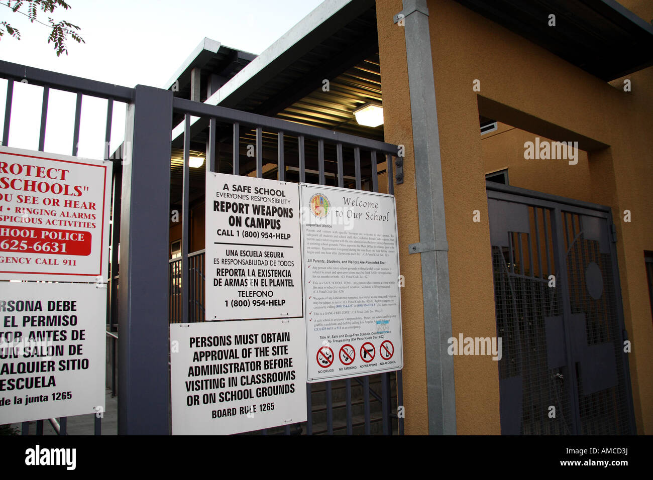 Sign on school fence warning against weapons Stock Photo - Alamy