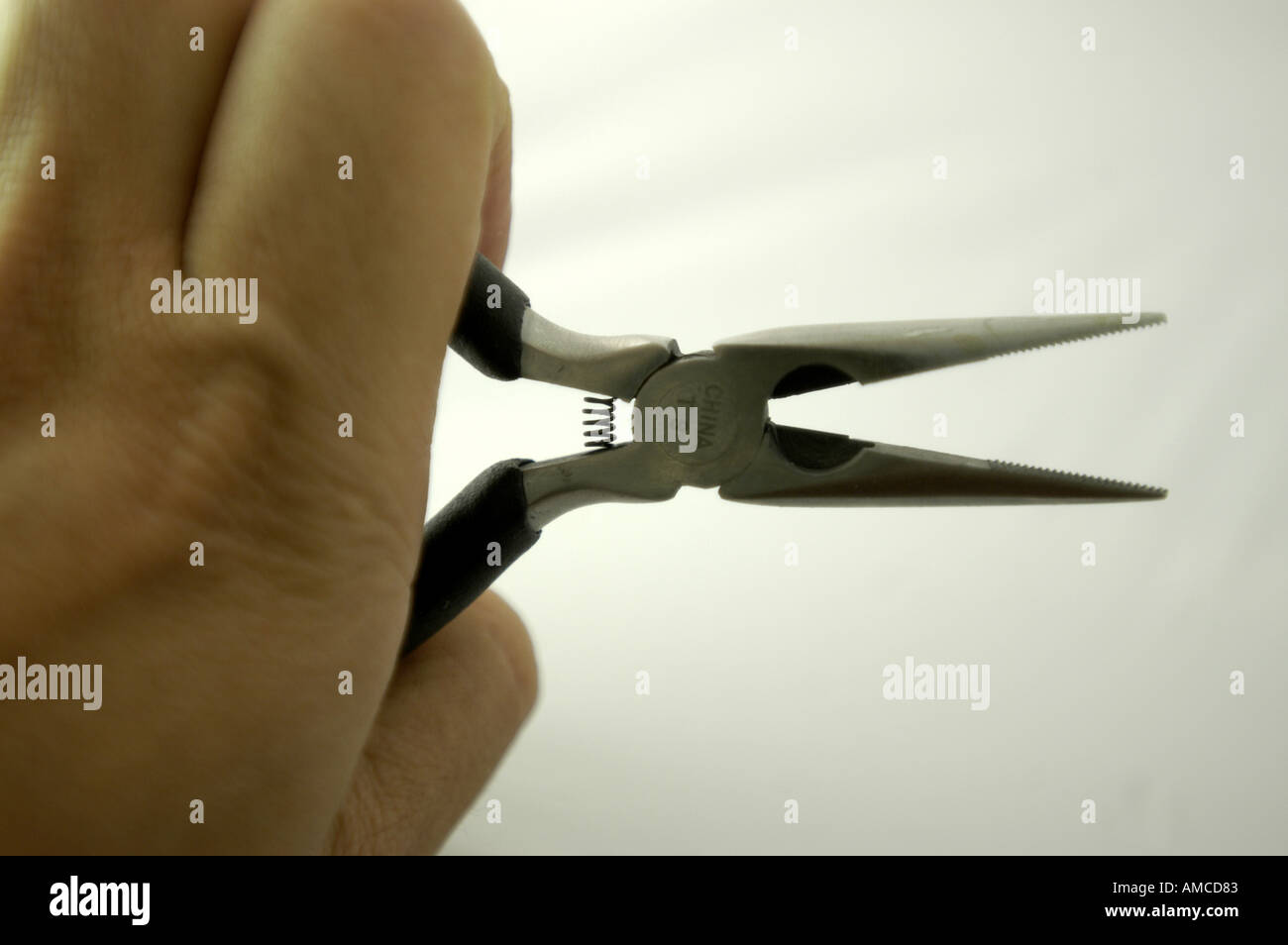 A close-up of a hand holding pliers Stock Photo - Alamy