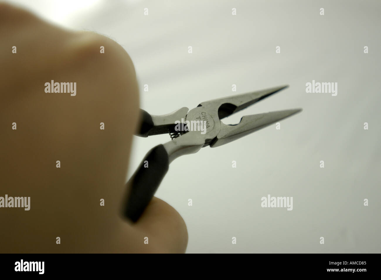 A close-up of a hand holding pliers Stock Photo - Alamy