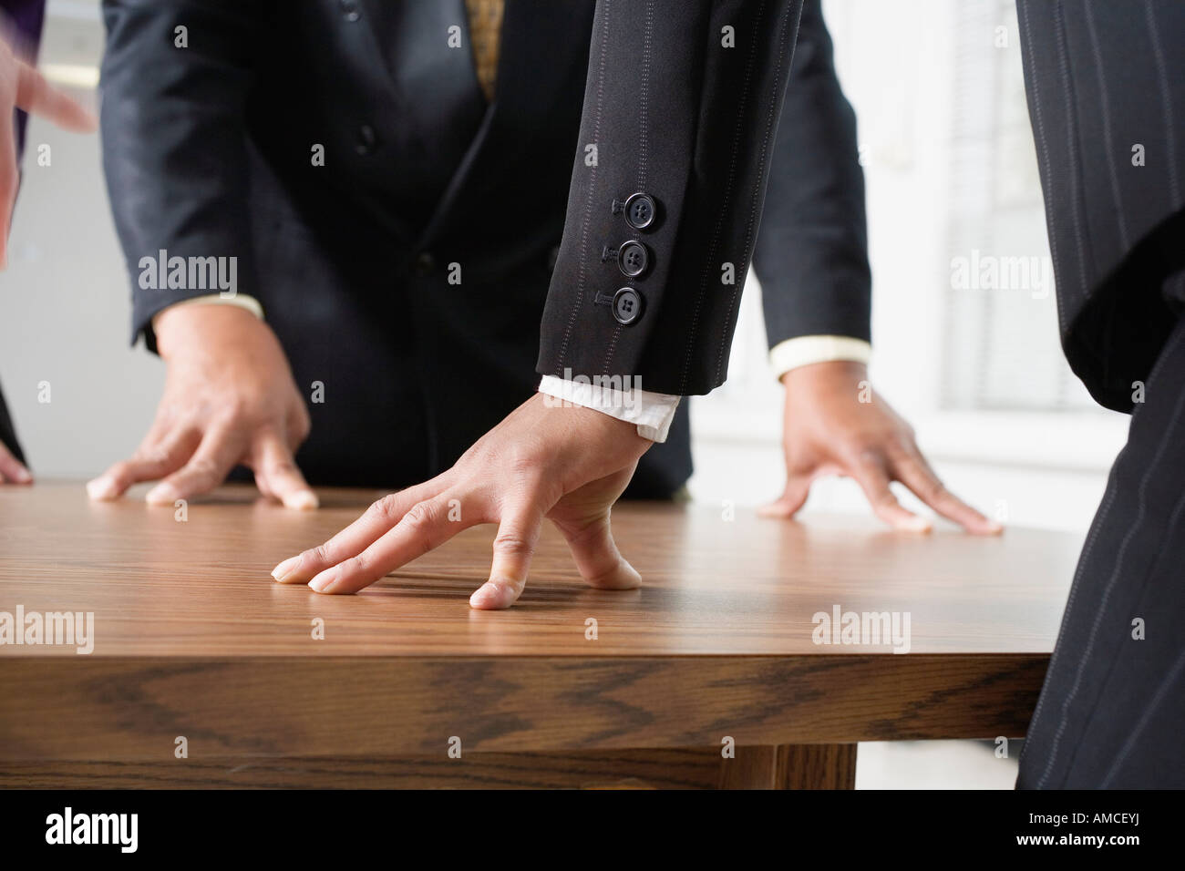 Midsection of people standing around a table Stock Photo - Alamy