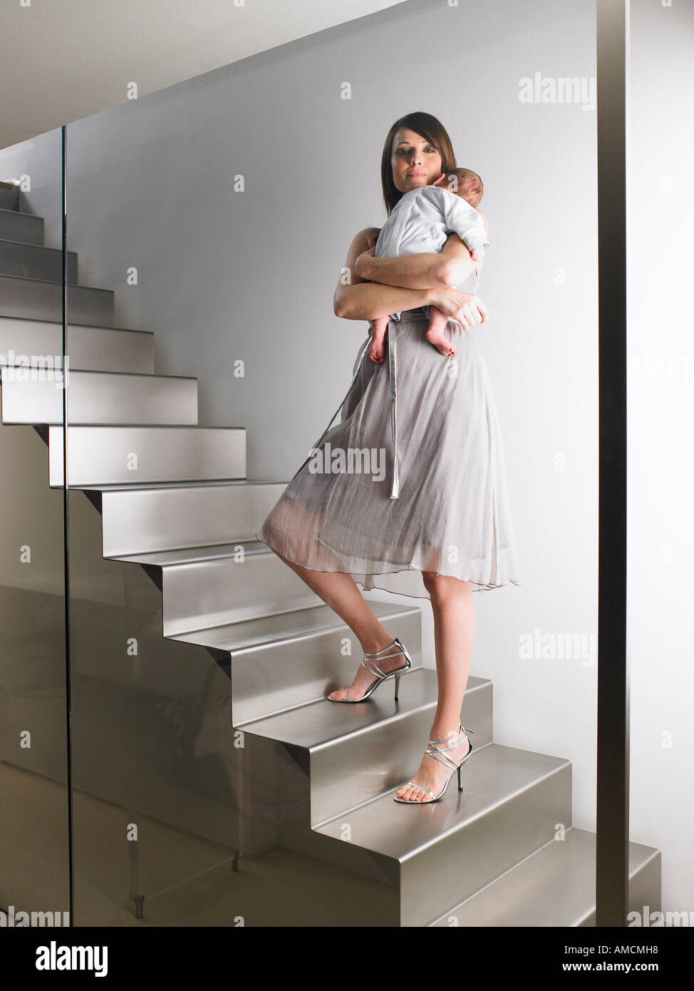 Mother Standing on Stairs with Baby Stock Photo - Alamy