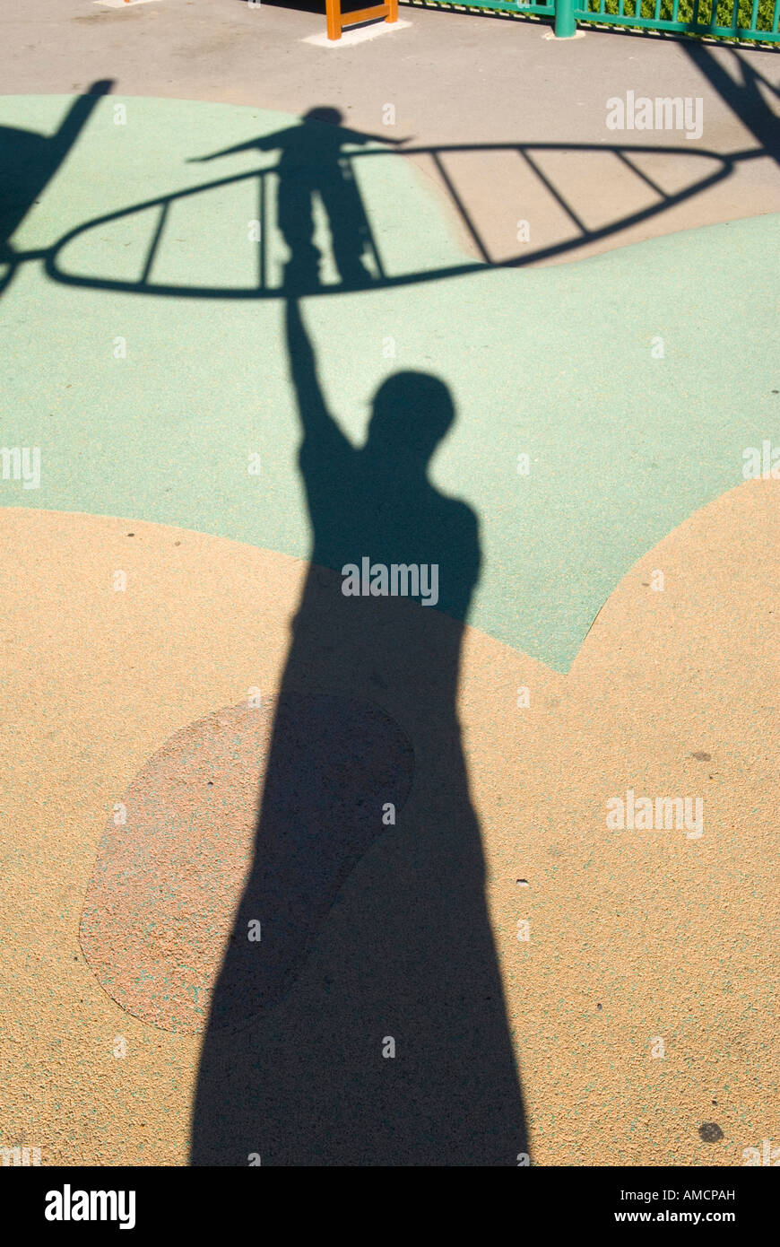 shadows of small child on climbing frame towering over shadow of adult ...