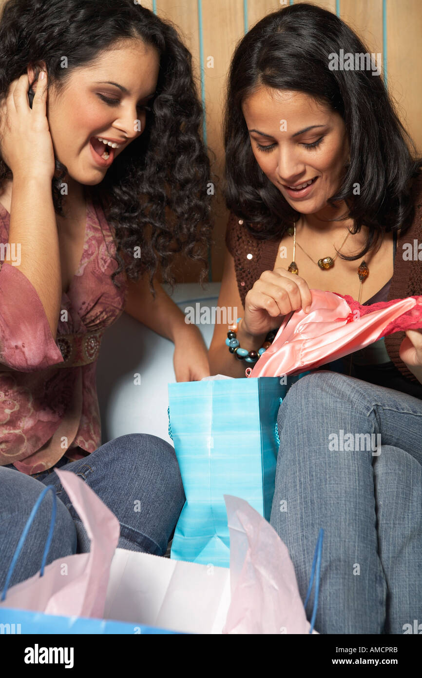 Two Women Looking Inside shopping Bags Stock Photo - Alamy