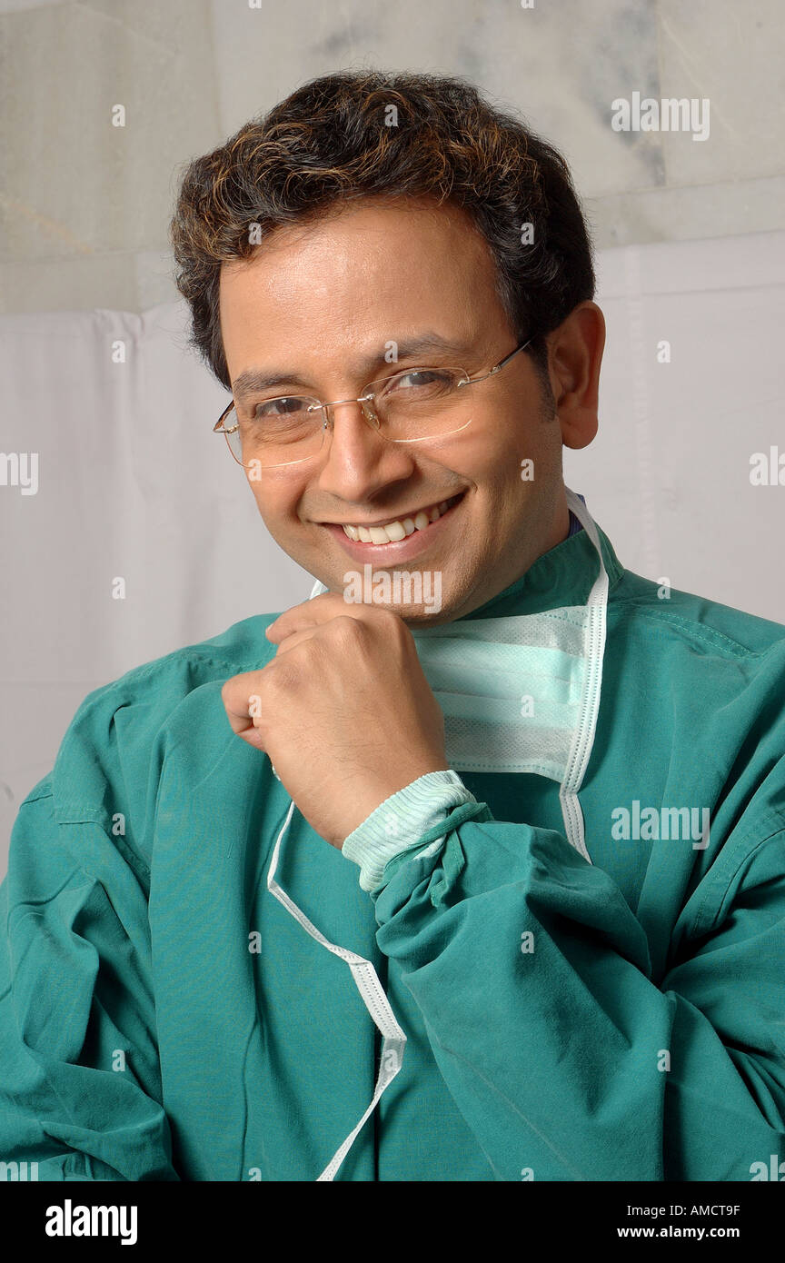 Indian Doctor surgeon in green operation theater coat and face mask ...