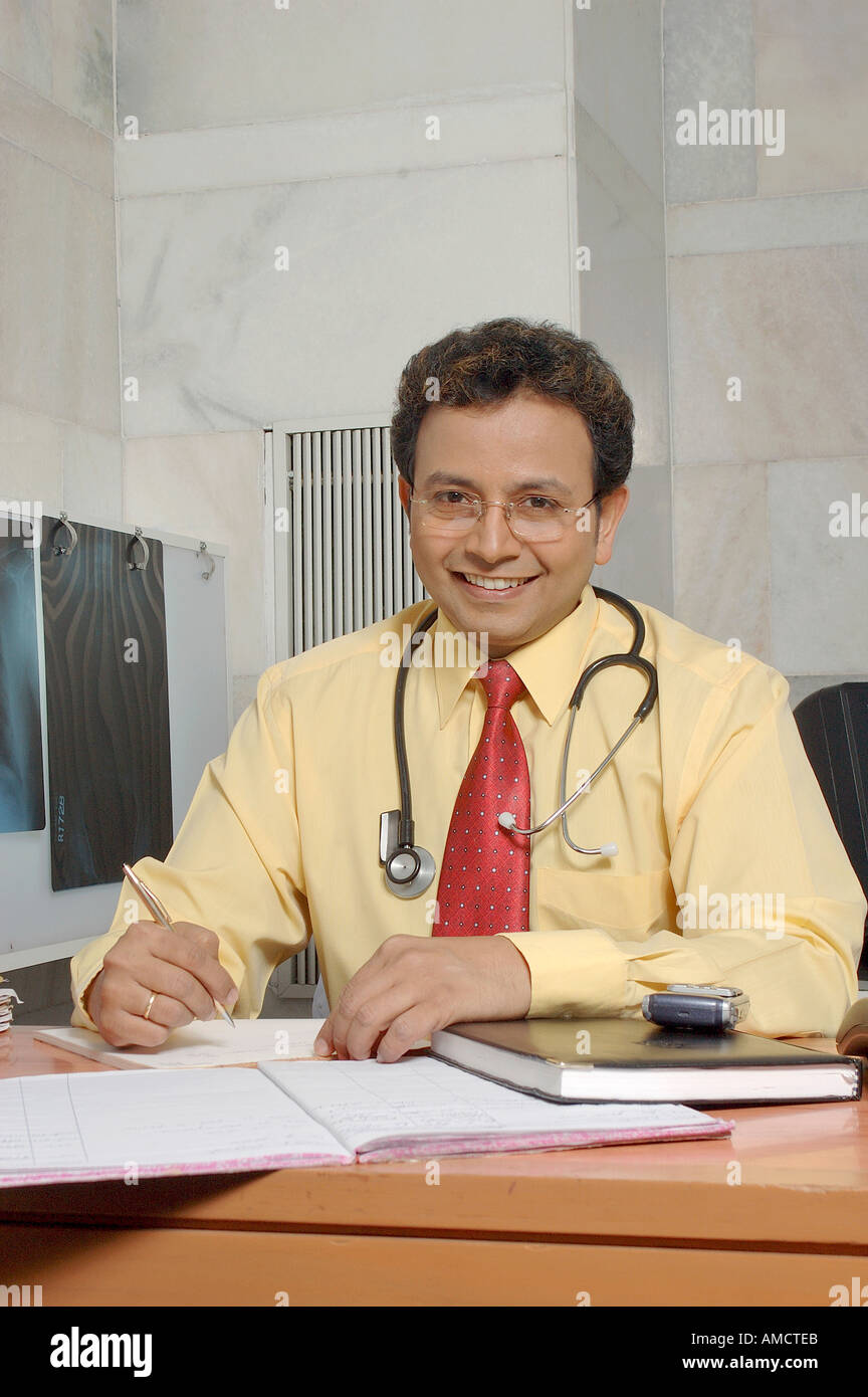 Indian Doctor with stethoscope in clinic writing prescription, Model ...