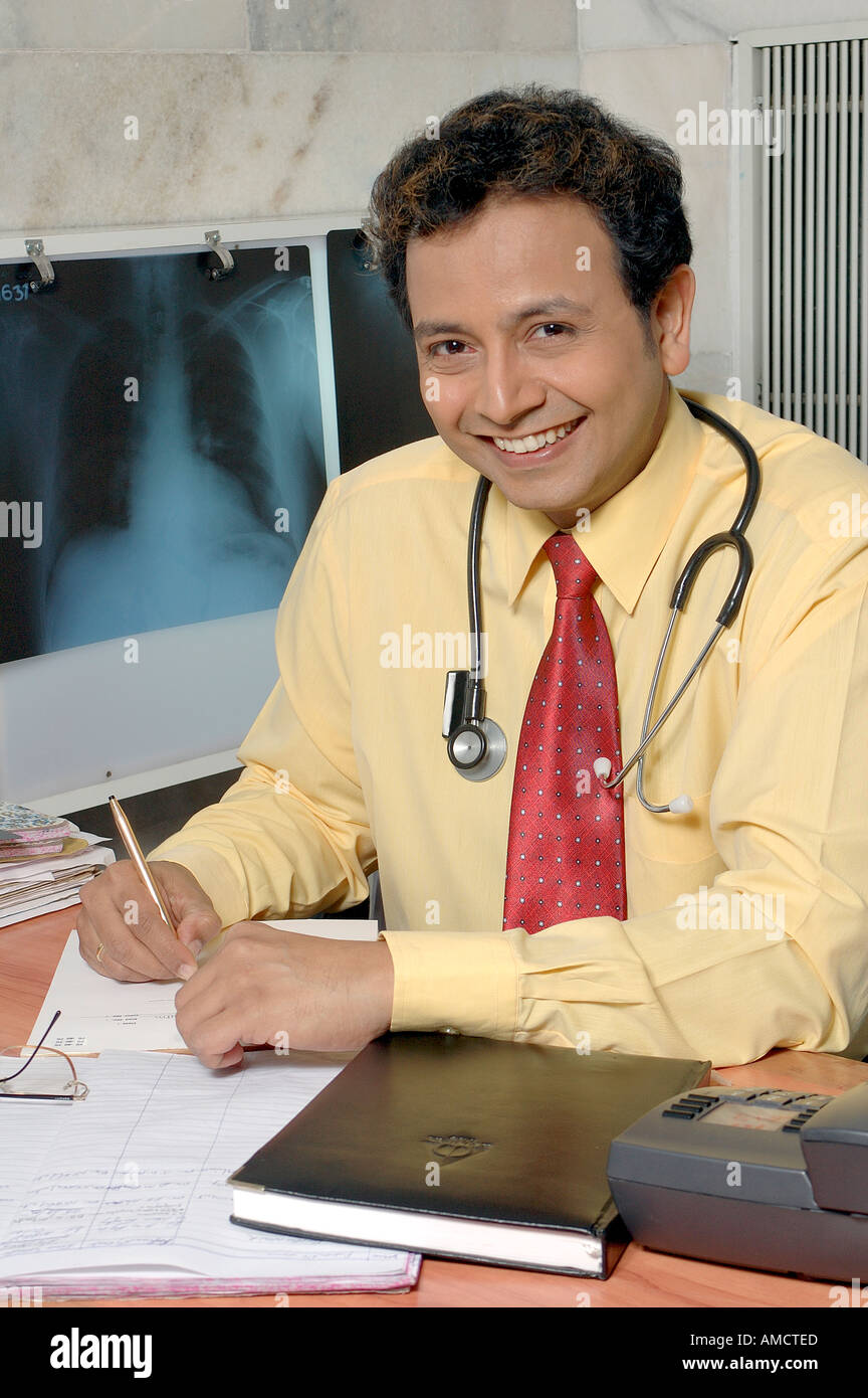 Indian Doctor with stethoscope in clinic writing prescription, Model ...