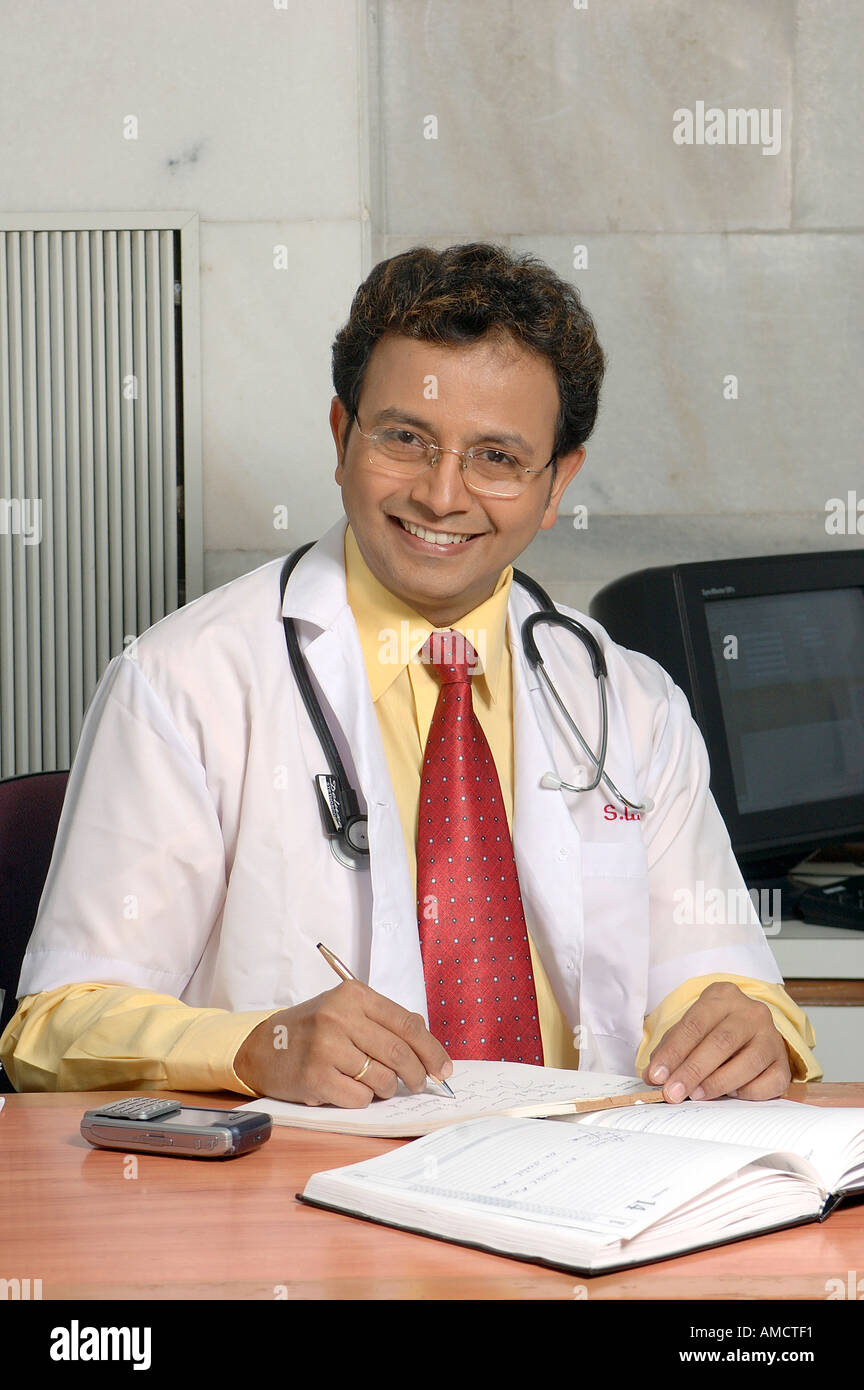 Indian Doctor with stethoscope in clinic writing prescription, Model ...
