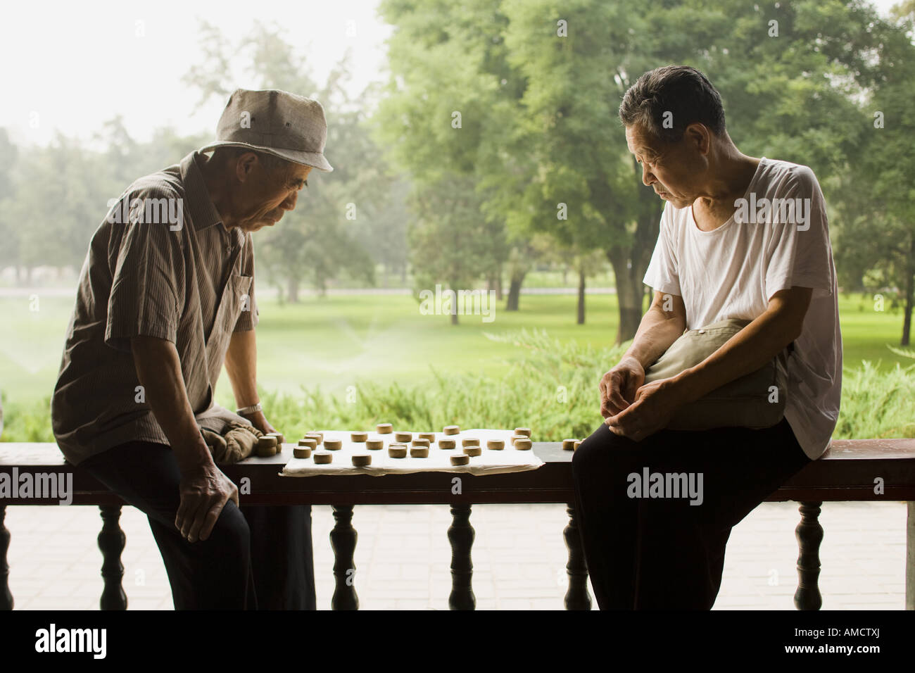 Two men sitting outdoors playing board game Stock Photo - Alamy