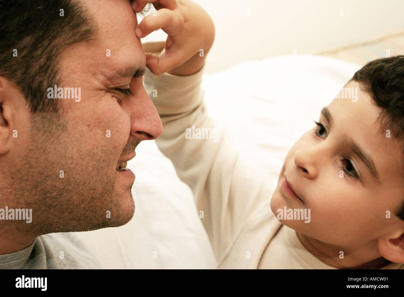 child with fingers on adult forehead Stock Photo - Alamy