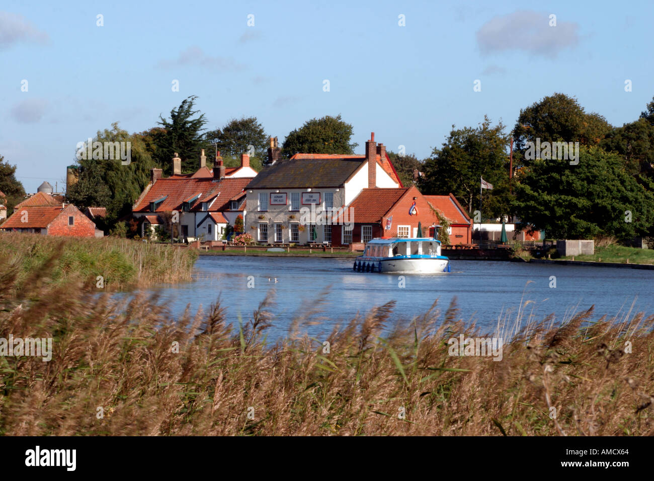 The Norfolk Broads A pleasure cruiser passes The Ferry Inn at Stokesby ...