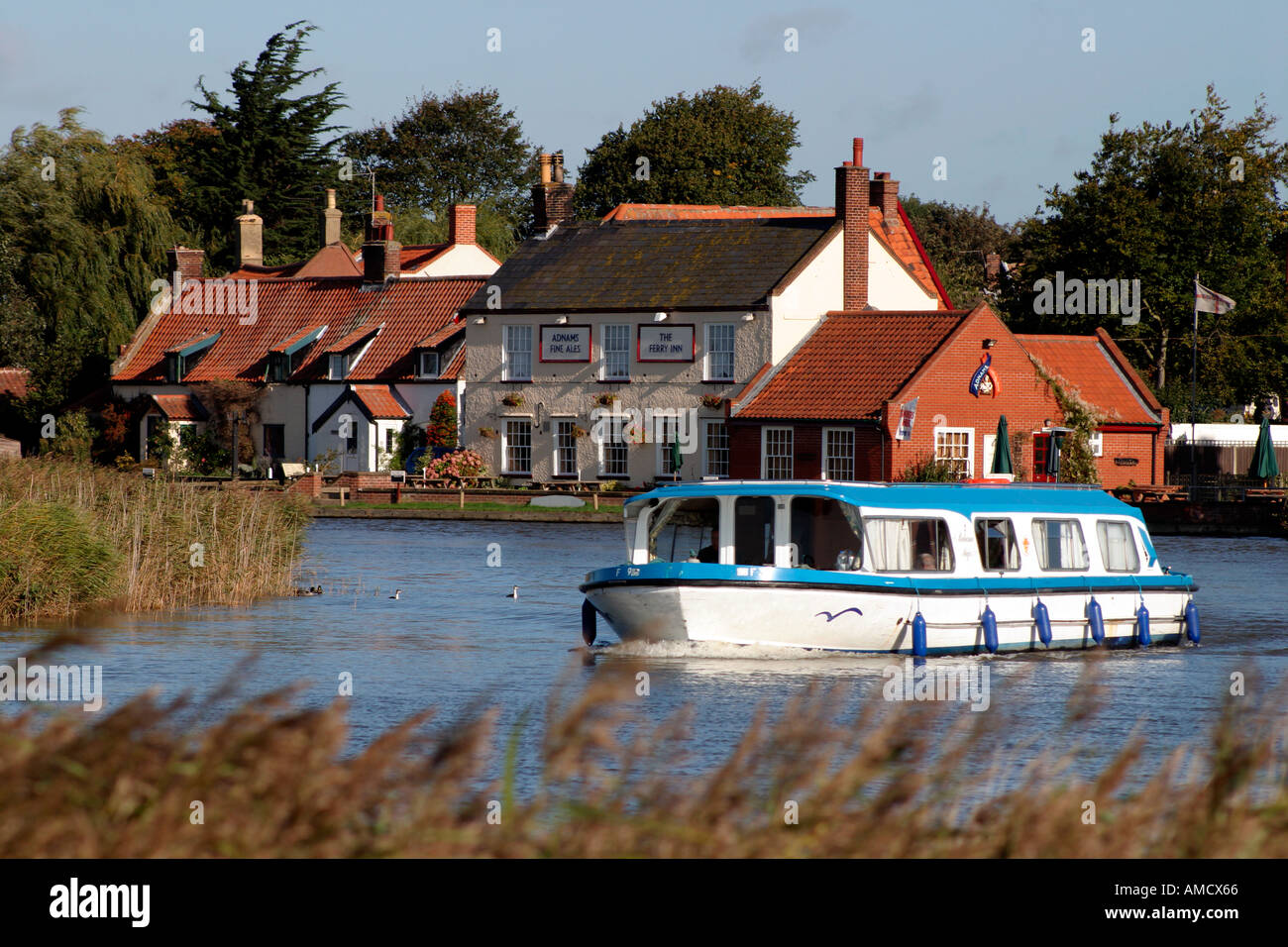 The Norfolk Broads: A pleasure cruiser passes The Ferry Inn at Stokesby ...