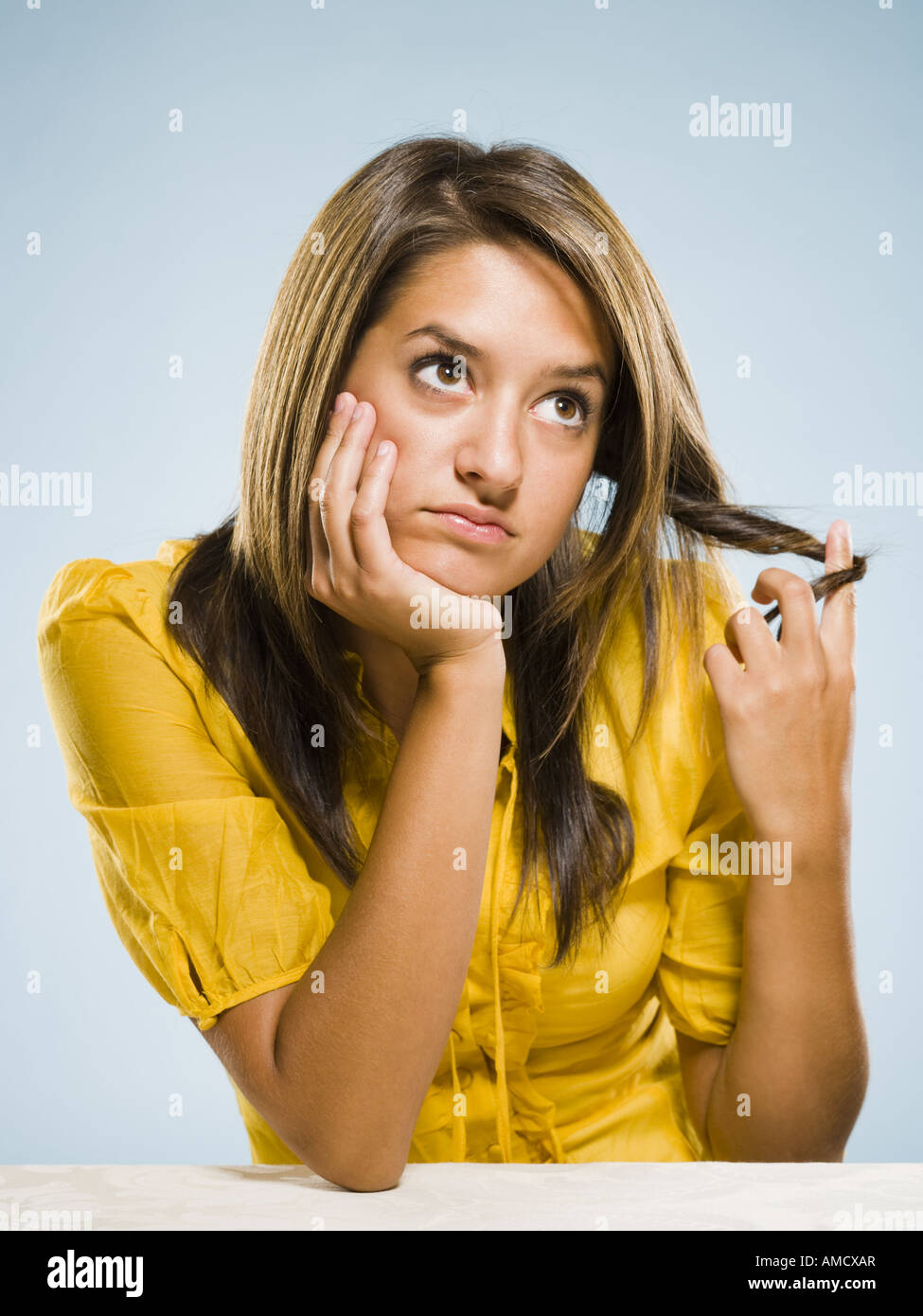 Woman twirling hair in hand Stock Photo - Alamy