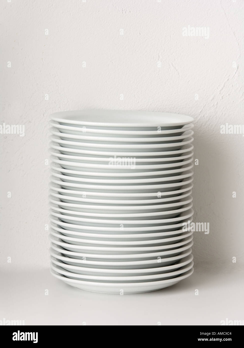 Stack of round white dinner plates on white background Stock Photo - Alamy