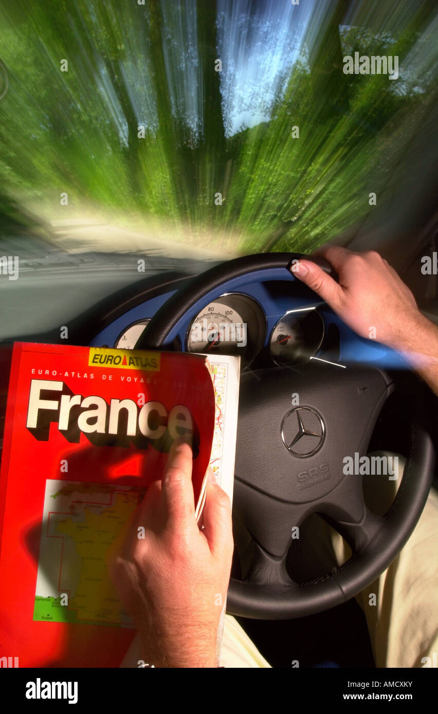 USING A MAP AT THE WHEEL WHILE DRIVING THROUGH FRANCE Stock Photo - Alamy