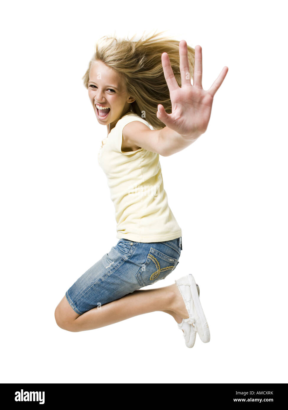 Girl smiling and leaping with hand up Stock Photo - Alamy