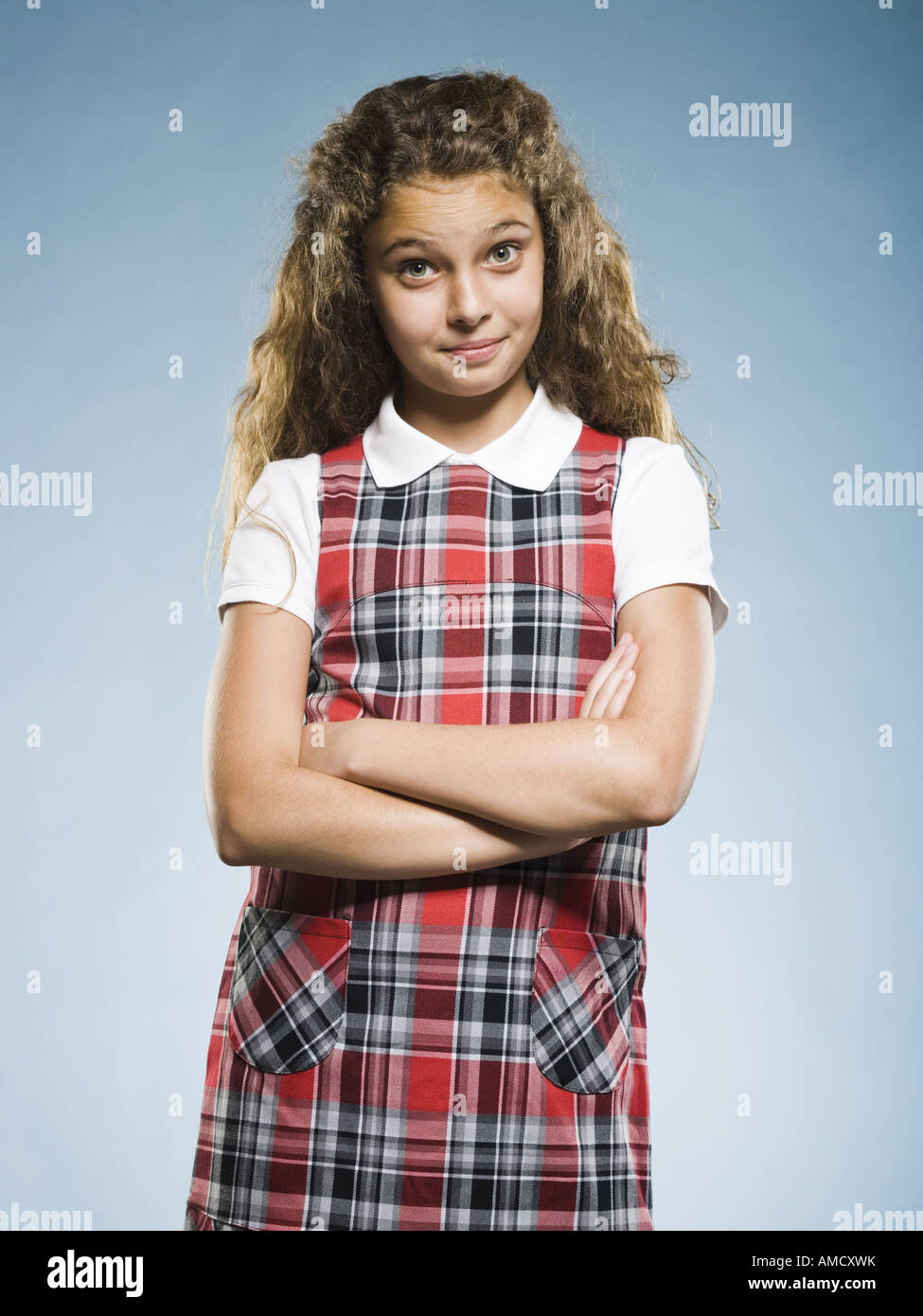 Girl standing with arms crossed smiling Stock Photo - Alamy