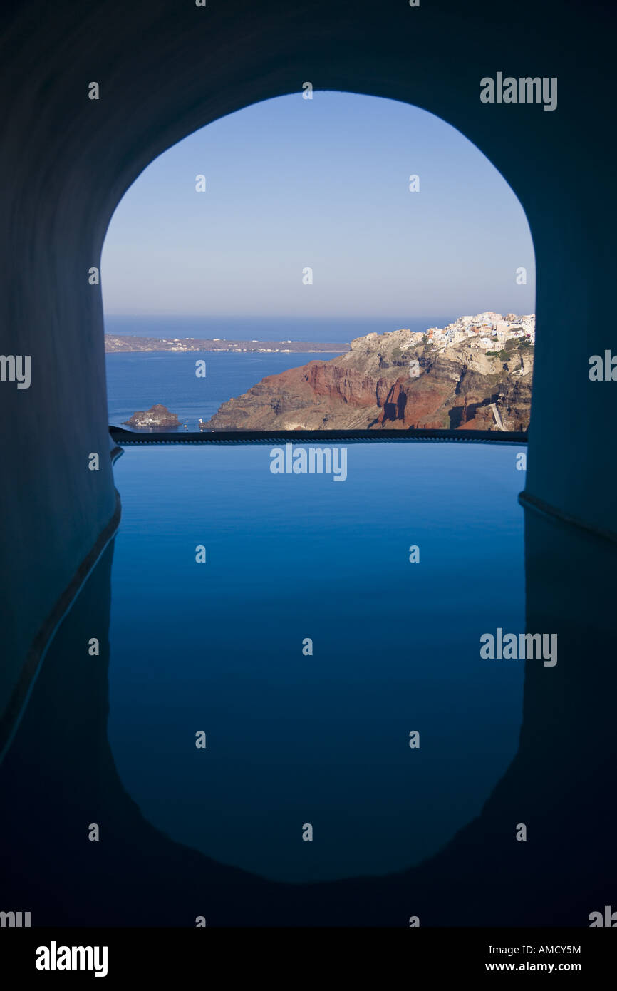 View of infinity pool through archway with mountains and water Stock ...