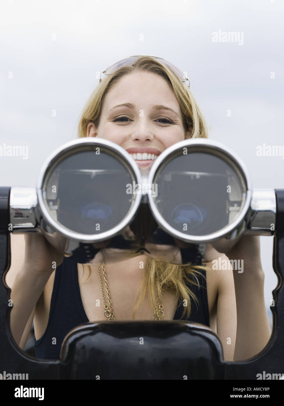 Woman with coin operated binoculars smiling Stock Photo - Alamy