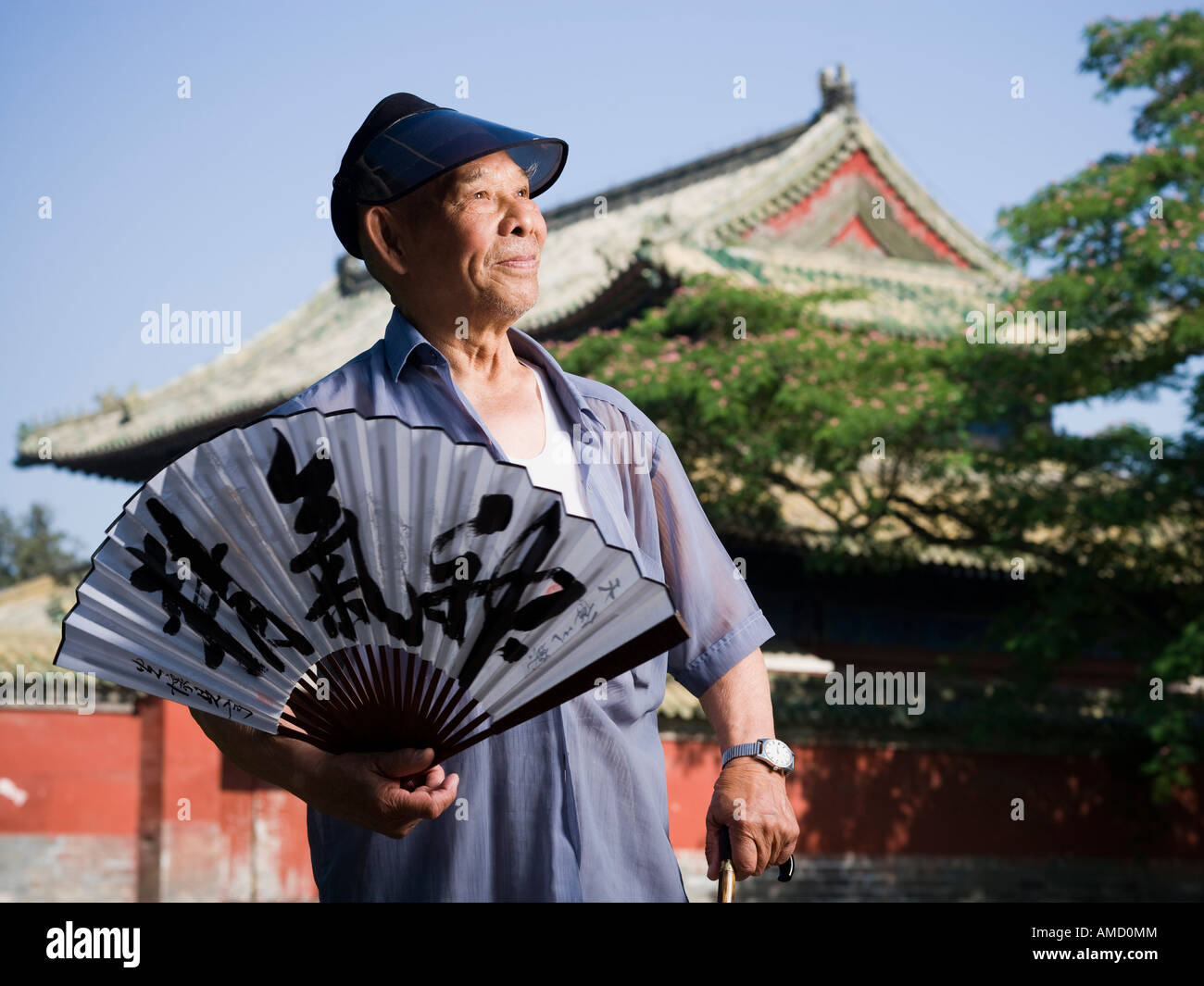 Man holding Chinese fan with pagoda and blue sky in background Stock ...