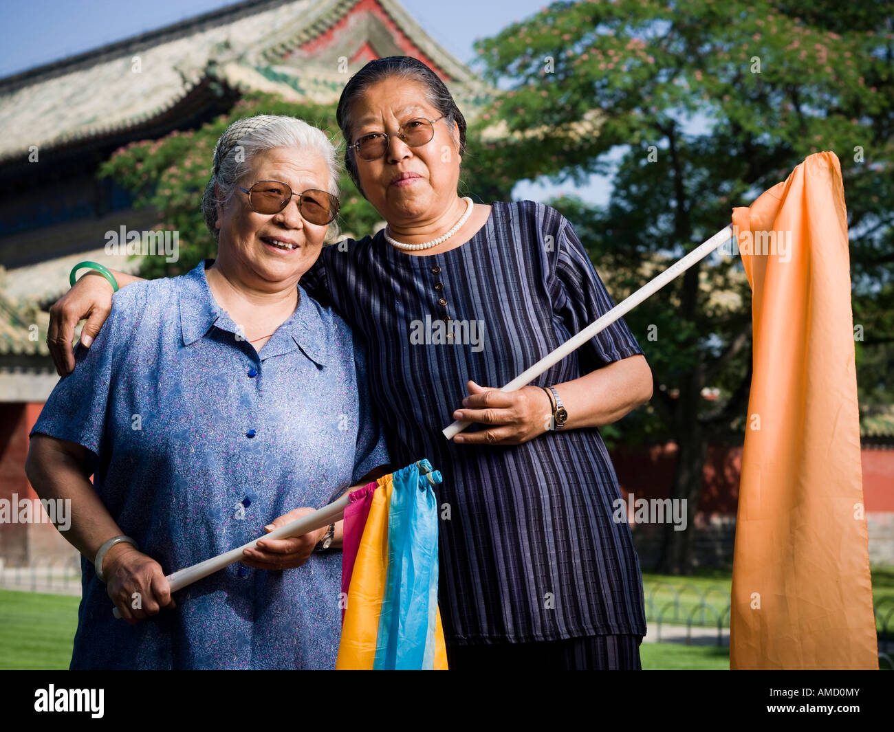 Two women embracing outdoors with flags and pagoda in background Stock ...