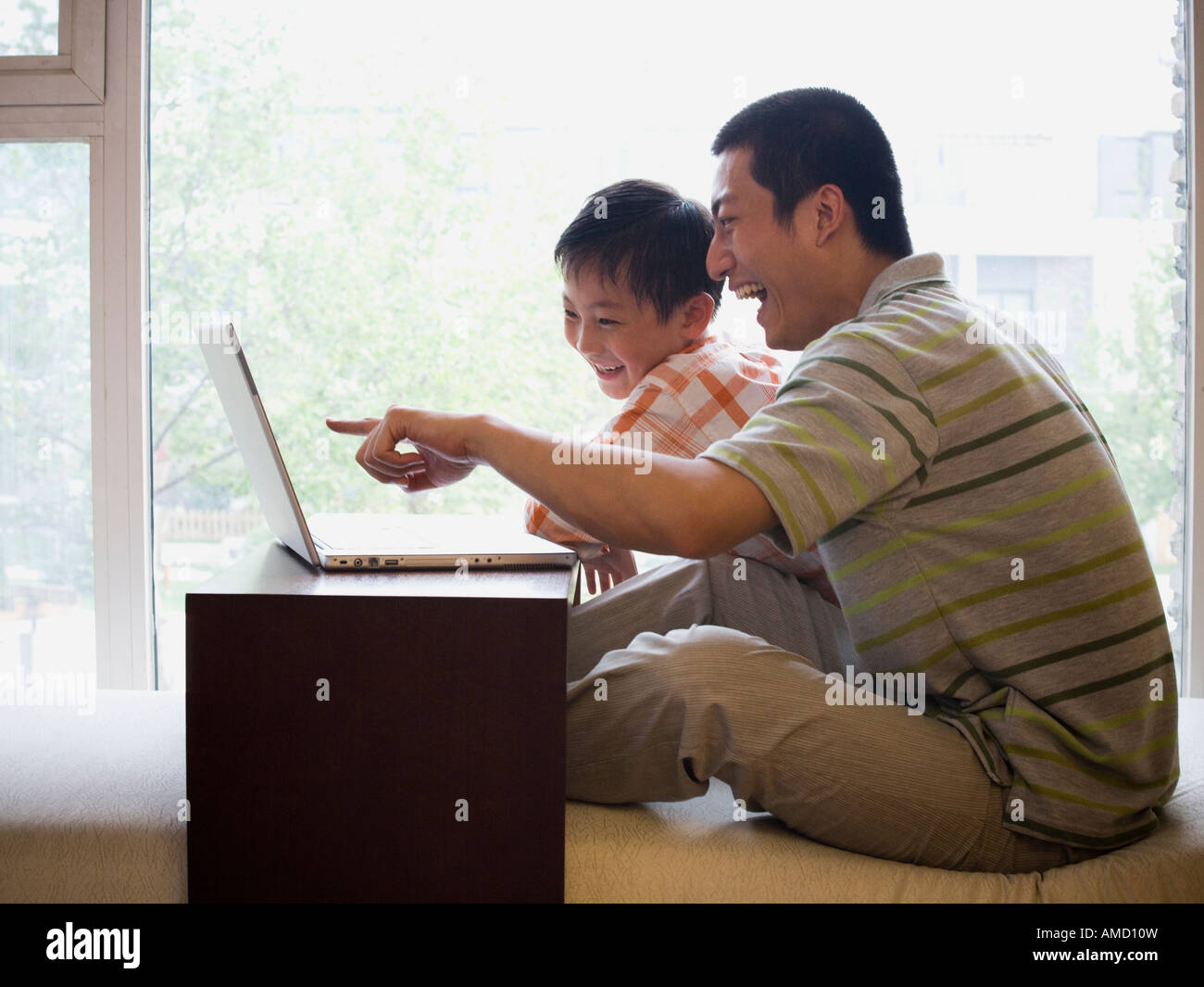 Man and boy sitting at computer Stock Photo - Alamy