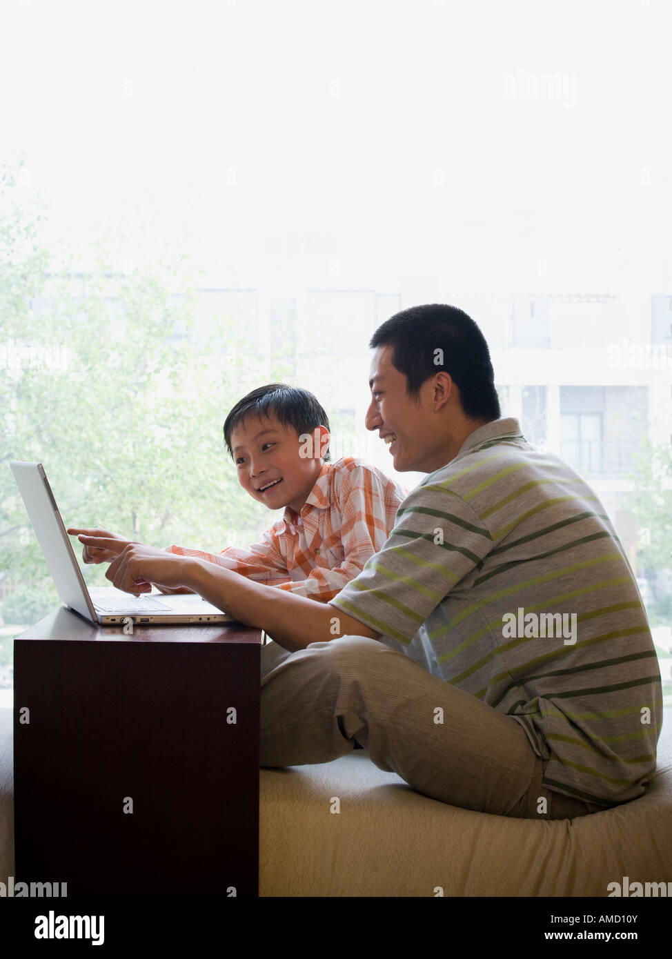 Man and boy sitting at computer Stock Photo - Alamy