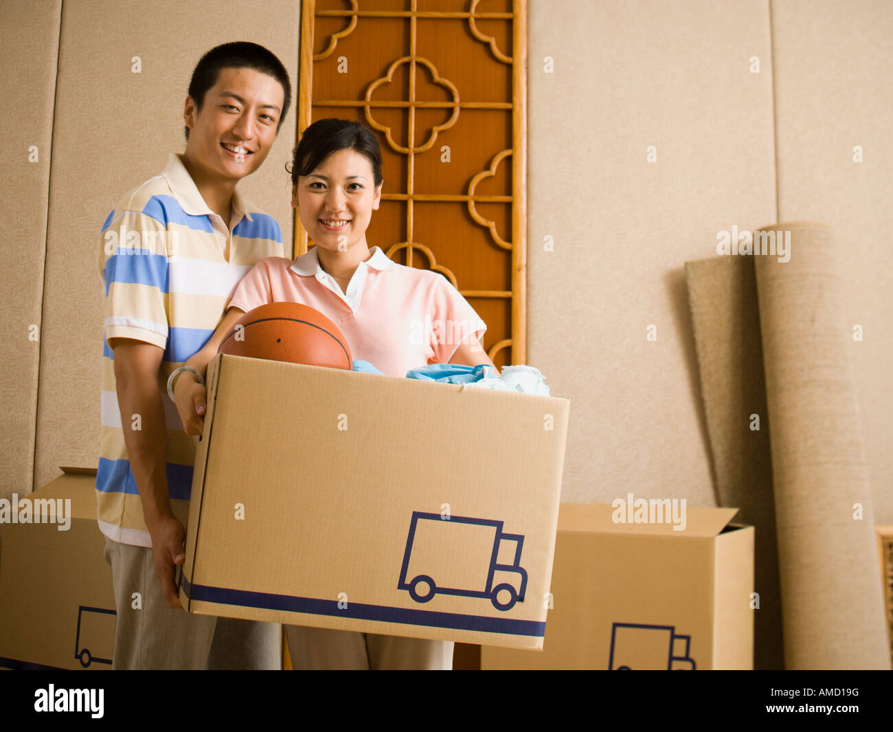Couple with cardboard box smiling Stock Photo - Alamy