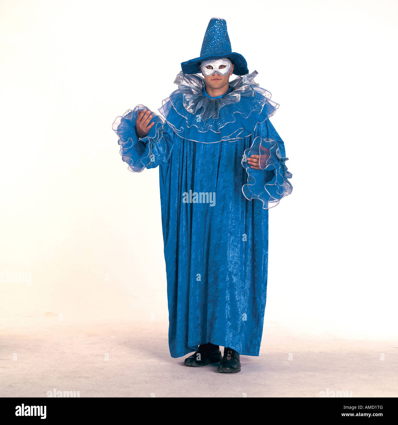 man dressed up as arlekin with blue uniform robe and mask for carnival ...