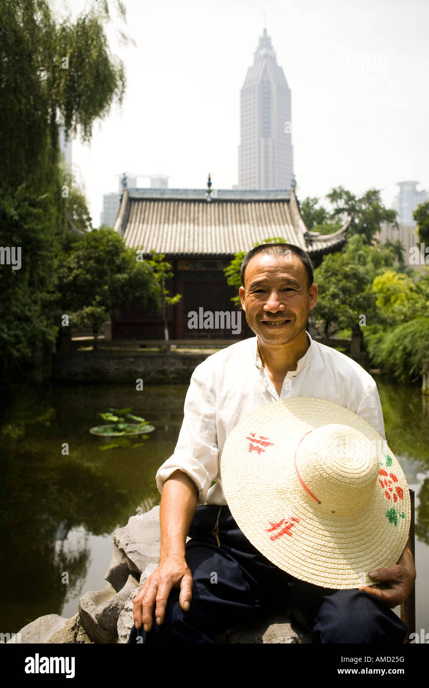 Man holding straw hat with city skyline in background Stock Photo - Alamy