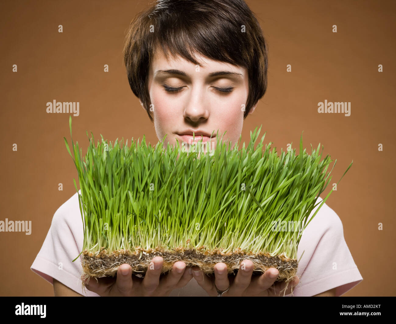 Woman holding grass and smelling it with eyes closed Stock Photo - Alamy