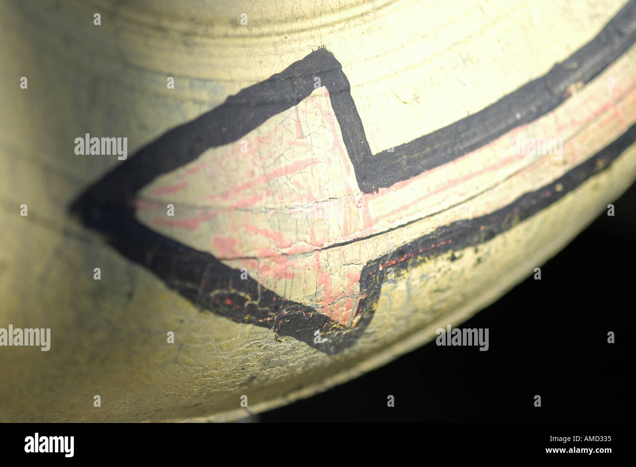 Big orange arrow black outline pointing left at bottom of rounded tan ...