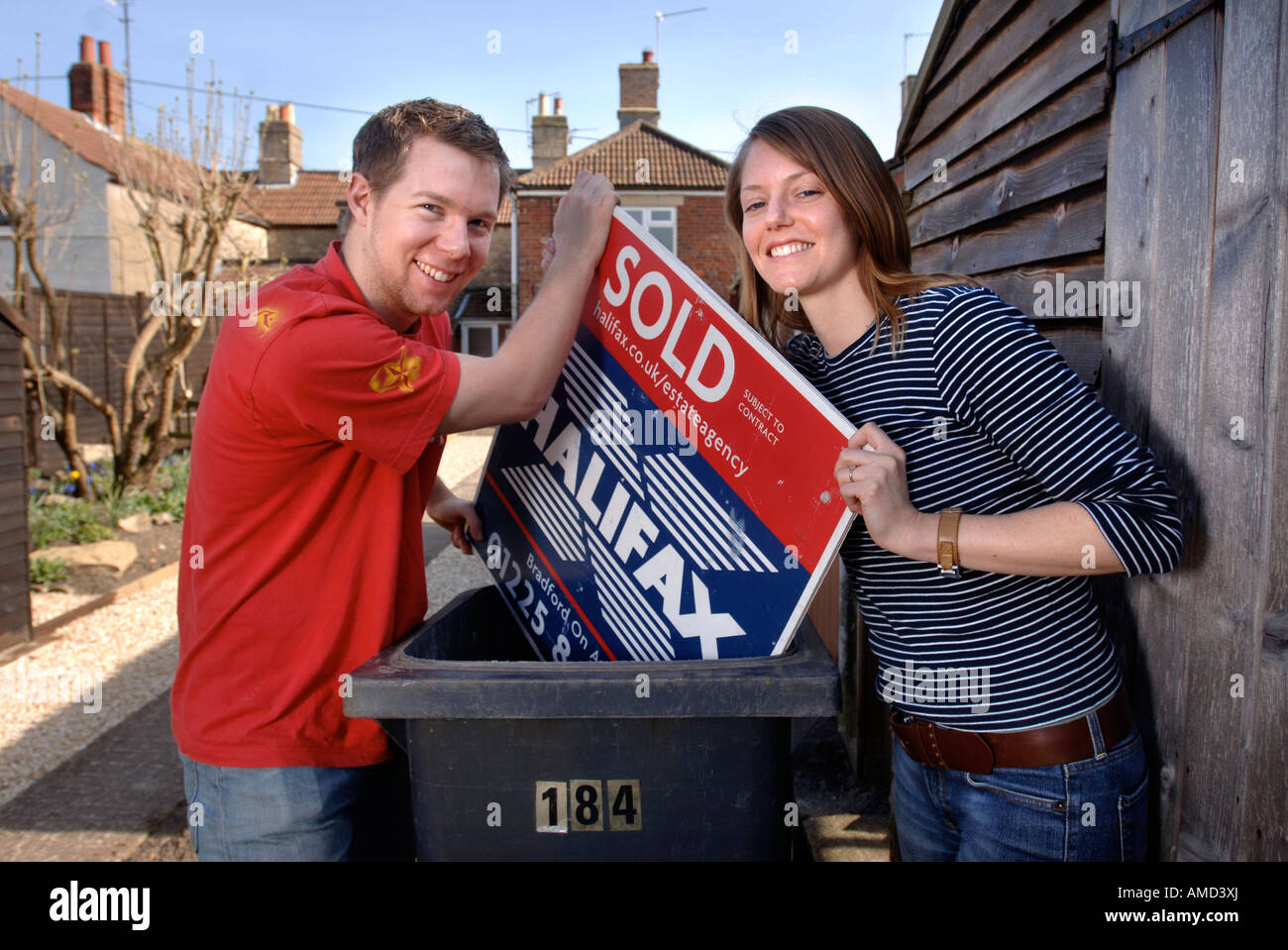 A YOUNG COUPLE MOVING INTO THEIR FIRST HOME PUT THE SOLD SIGN IN A ...