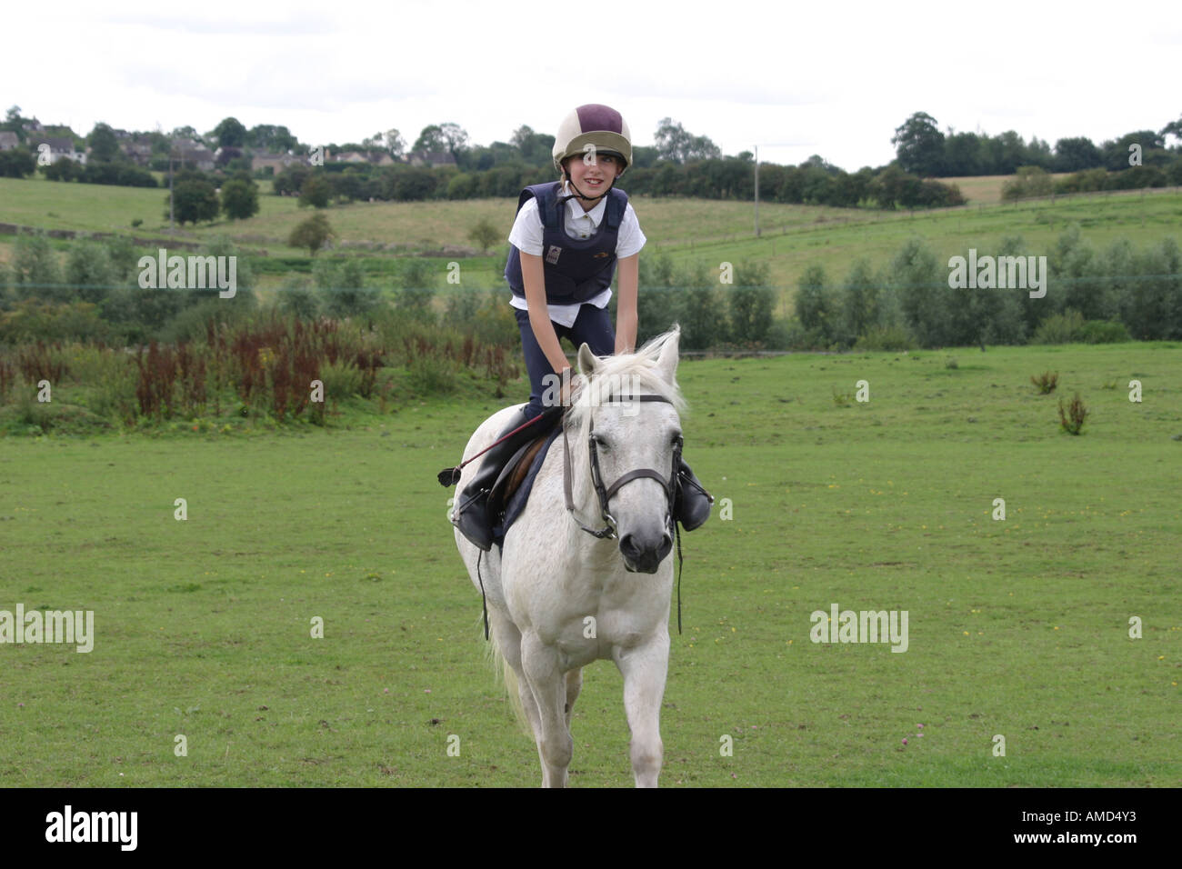 A young rider high in her saddle riding her pony Stock Photo - Alamy