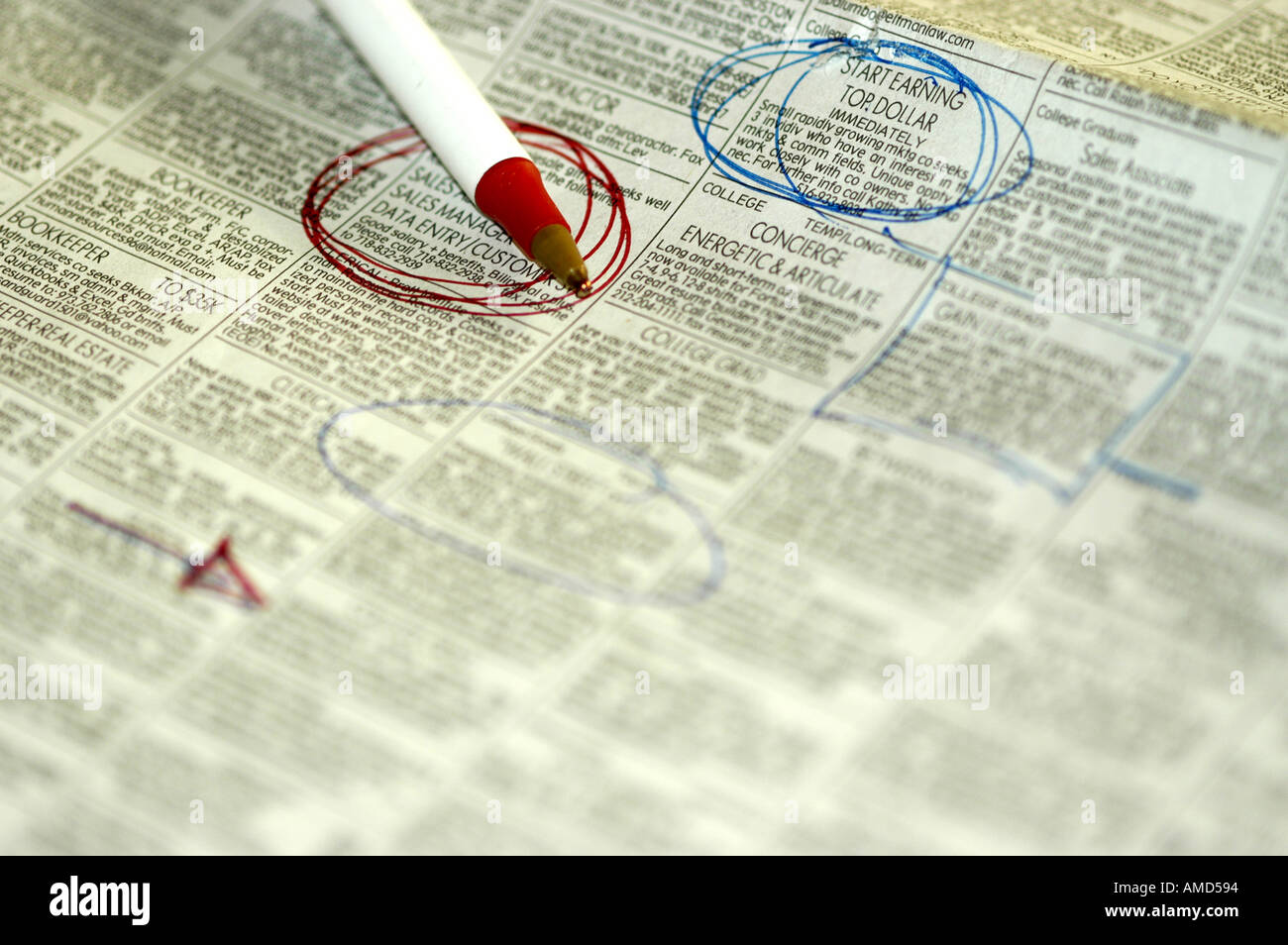 Newspaper classifieds red pen tip red circle blue circle above ...