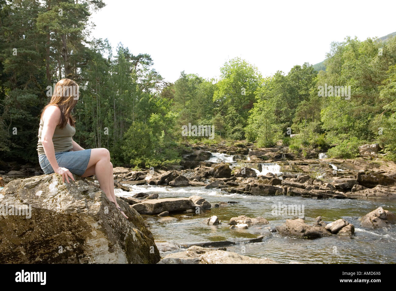 Young woman sitting by the Falls of Dochart in Perthsire Scotland Stock ...