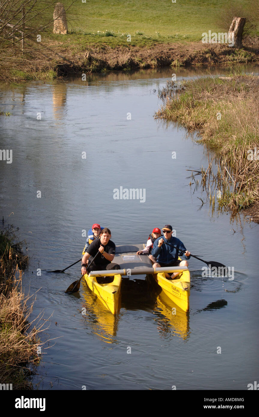 A FATHER WITH HIS TWO CHILDREN AND A GUIDE PADDLE DOWN THE RIVER THAMES ...
