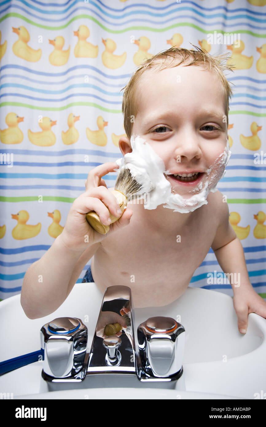 Boy shaving in bathroom and smiling Stock Photo - Alamy
