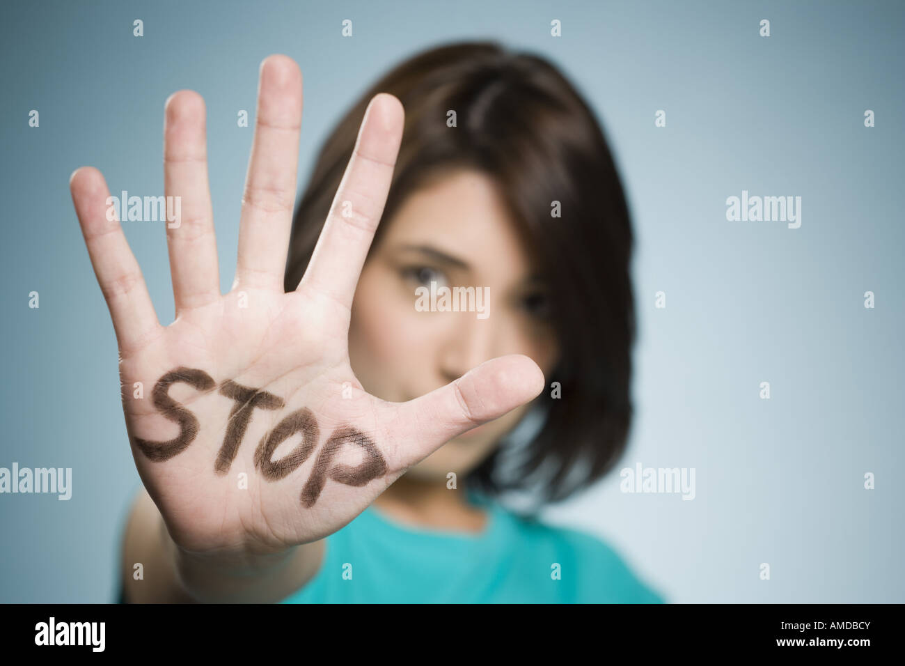 Woman with hand up and stop written on it Stock Photo - Alamy