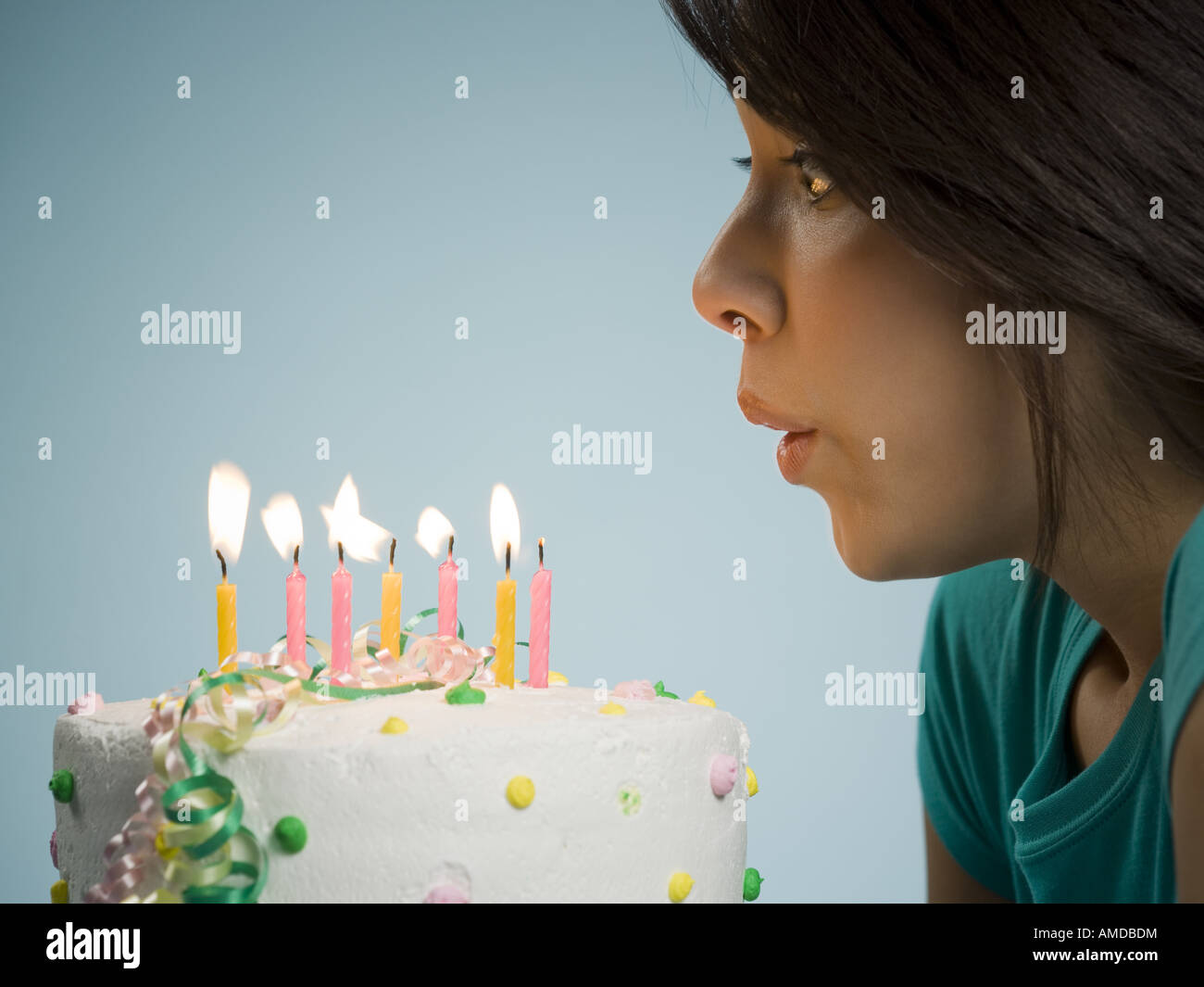Profile of woman blowing out candles on birthday cake Stock Photo - Alamy