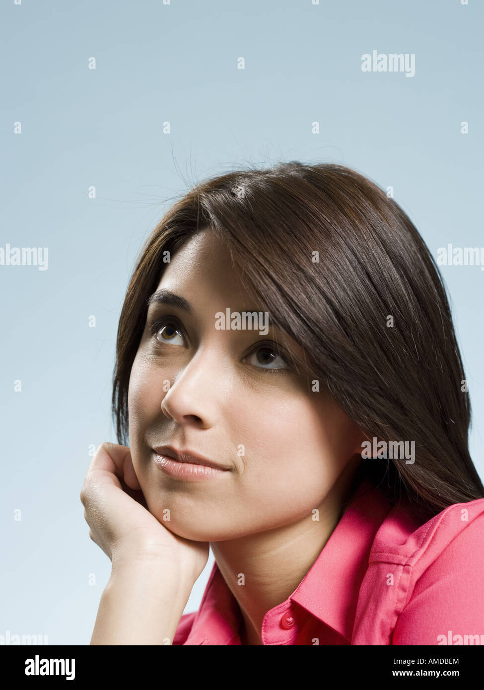Girl with hand on face looking up Stock Photo - Alamy