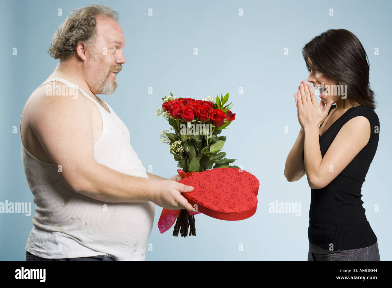 Disheveled man with heart box and red roses with excited woman Stock ...