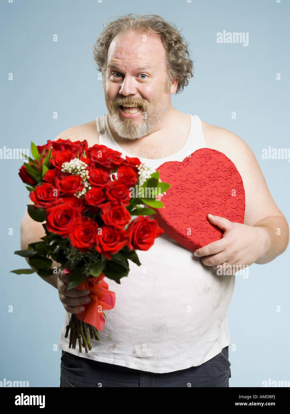 Disheveled man with red roses and heart box smiling Stock Photo - Alamy